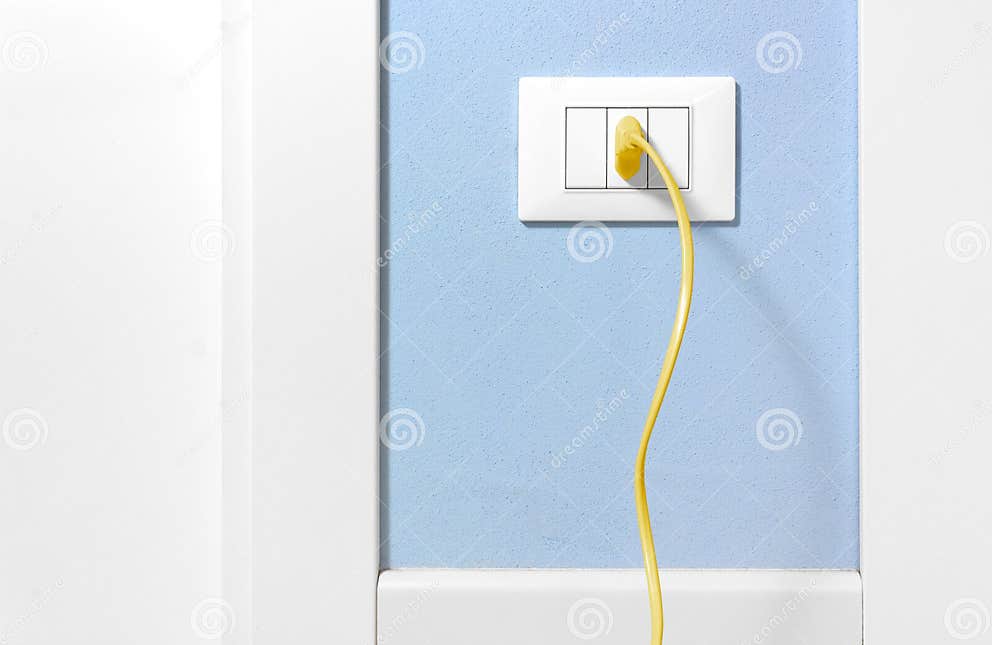 Yellow Plug in a Wall Socket on a Blue Wall Stock Image - Image of ...