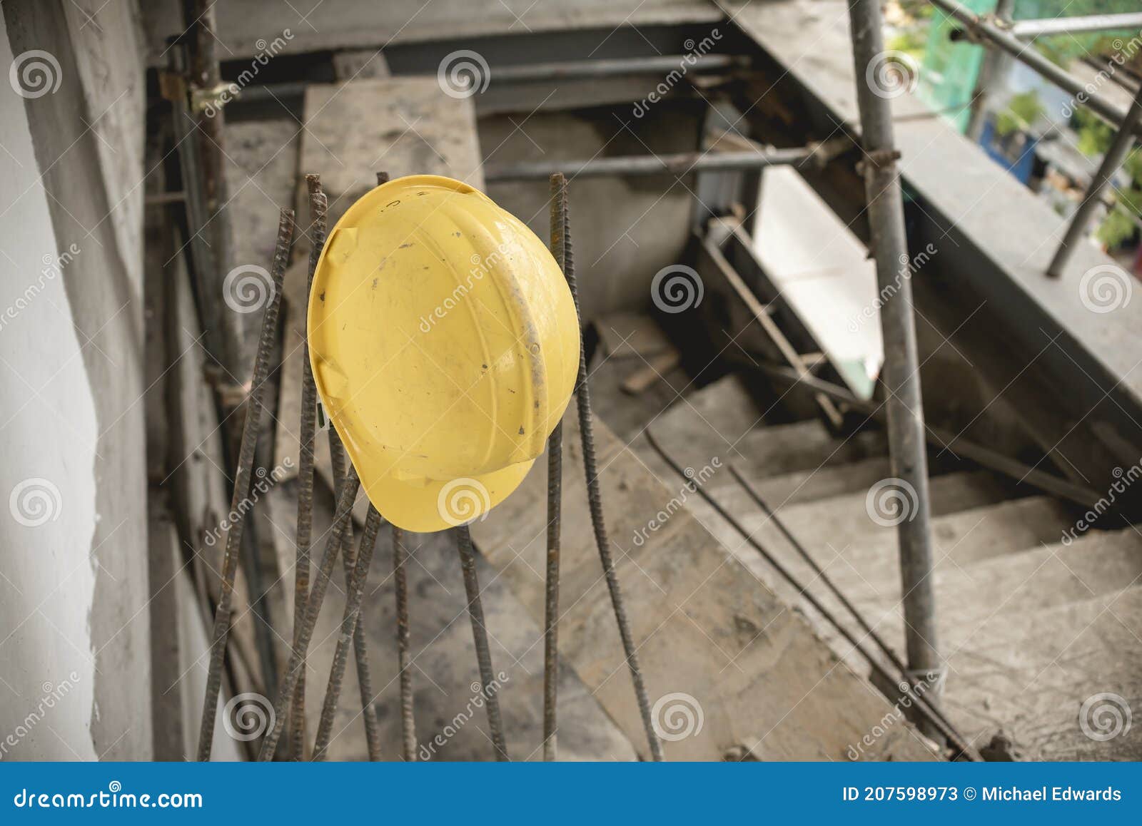 A Yellow Safety Helmet Hangs on Some Exposed Rebars at a Construction ...