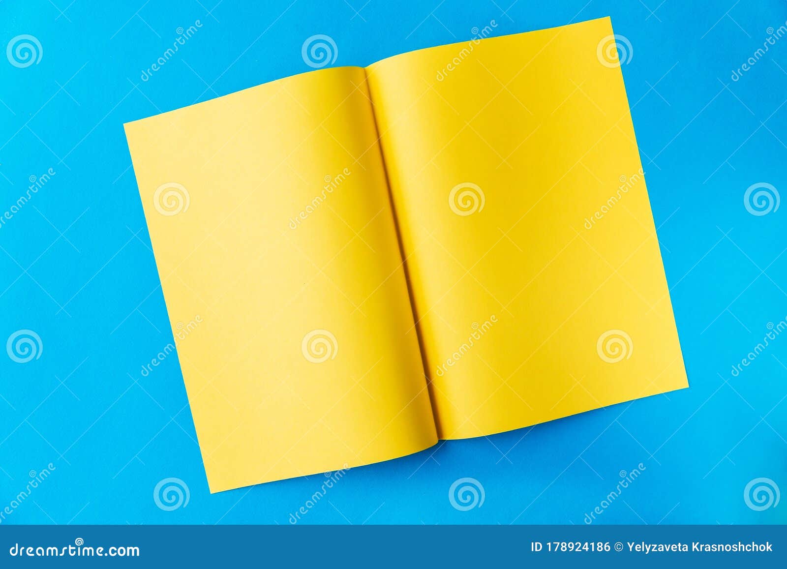 Yellow Sheet Of A3 Paper Folded In The Middle In A Spread On A Blue ...