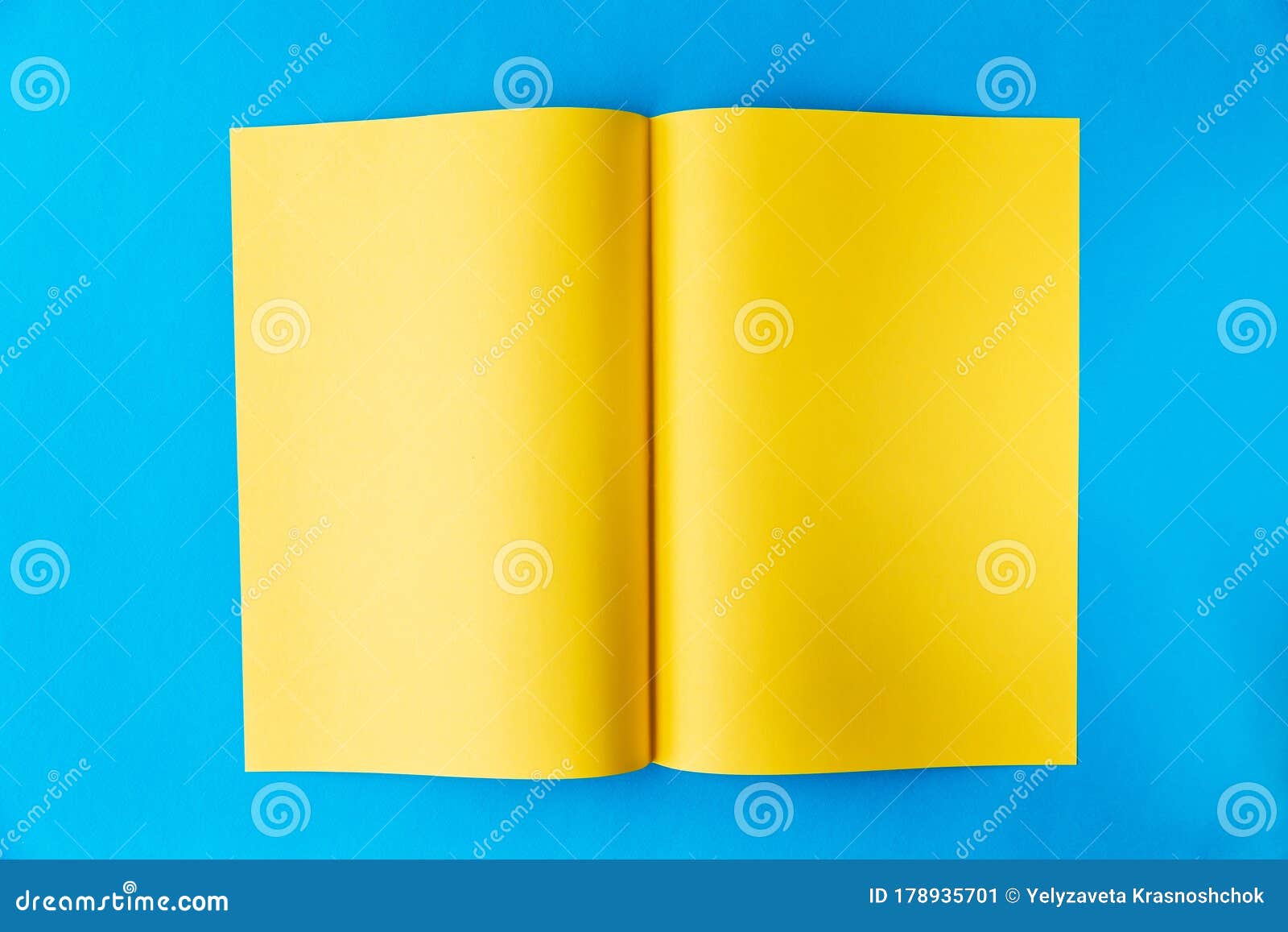 Yellow Sheet Of A3 Paper Folded In The Middle In A Spread On A Blue ...