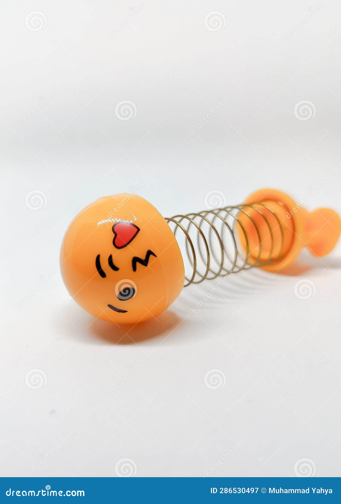 Yellow Spring Toy with Emoticon Face Shape on White Background Stock ...