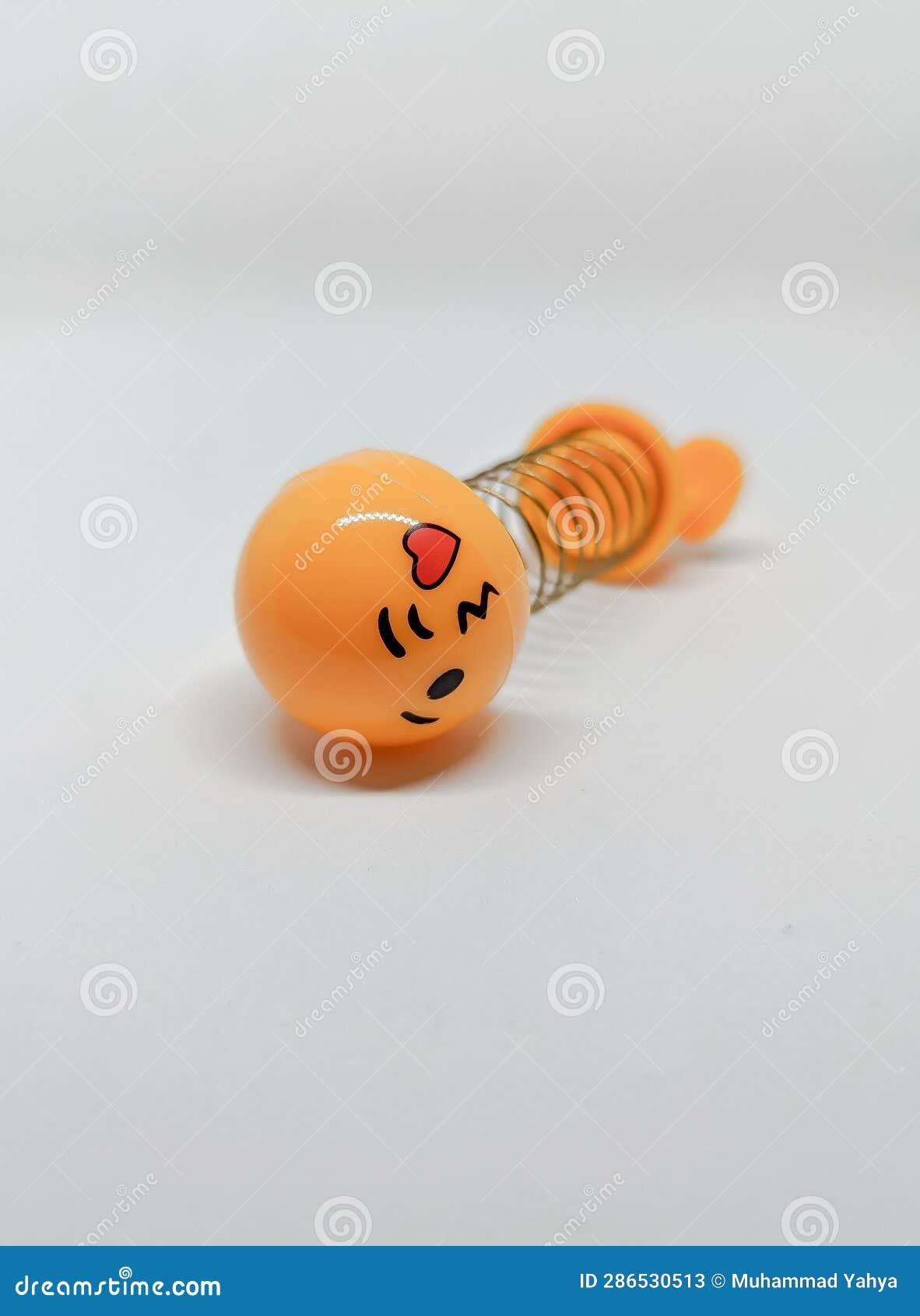 Yellow Spring Toy with Emoticon Face Shape on White Background Stock ...