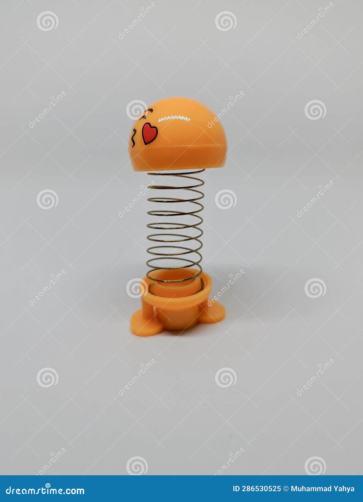 Yellow Spring Toy with Emoticon Face Shape on White Background Stock ...