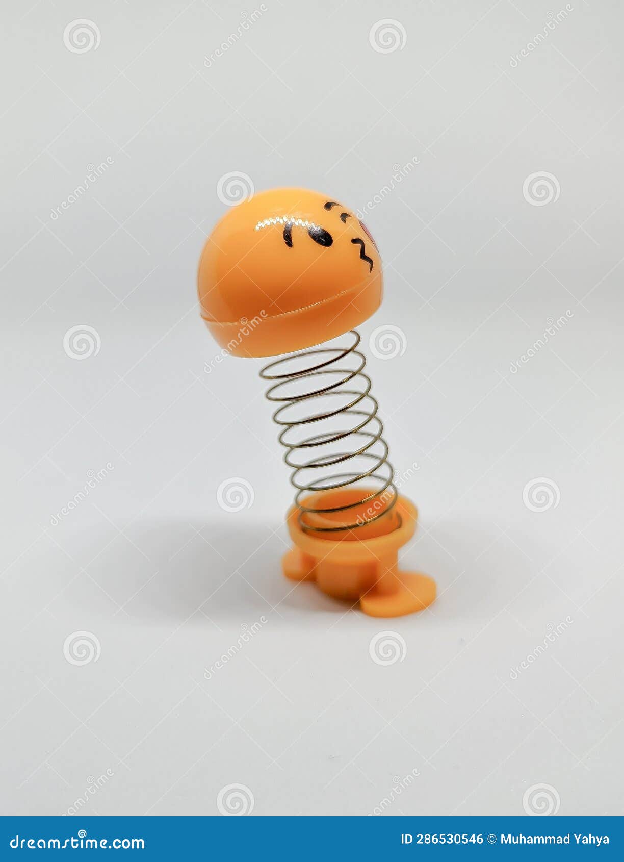 Yellow Spring Toy with Emoticon Face Shape on White Background Stock ...