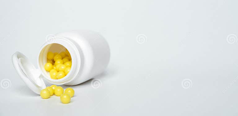 Yellow Tablets of Ascorbic Acid in Jar and Lie on a White Table Stock ...