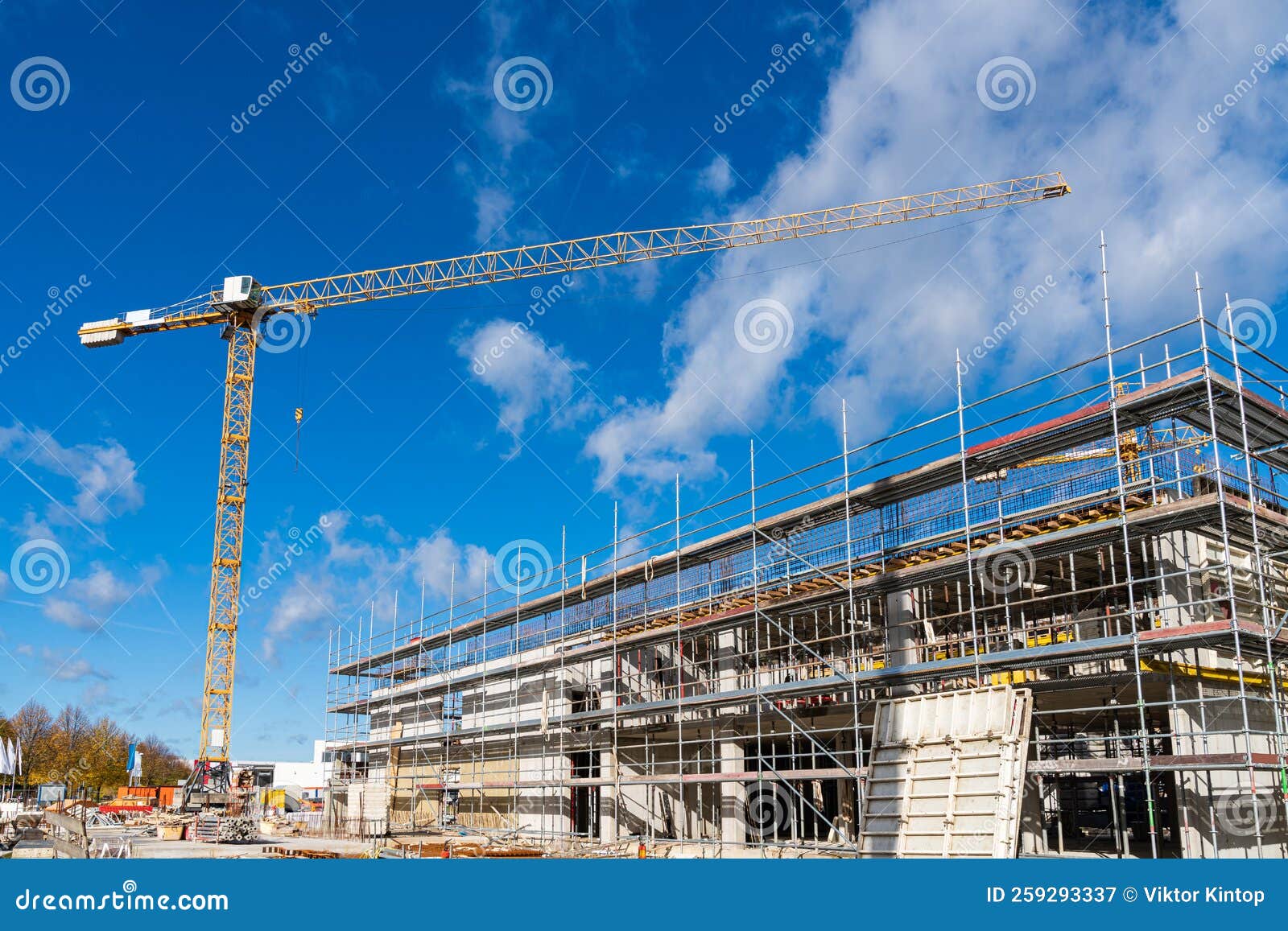 Yellow Tower Crane Above a Building Under Construction in Scaffolding ...