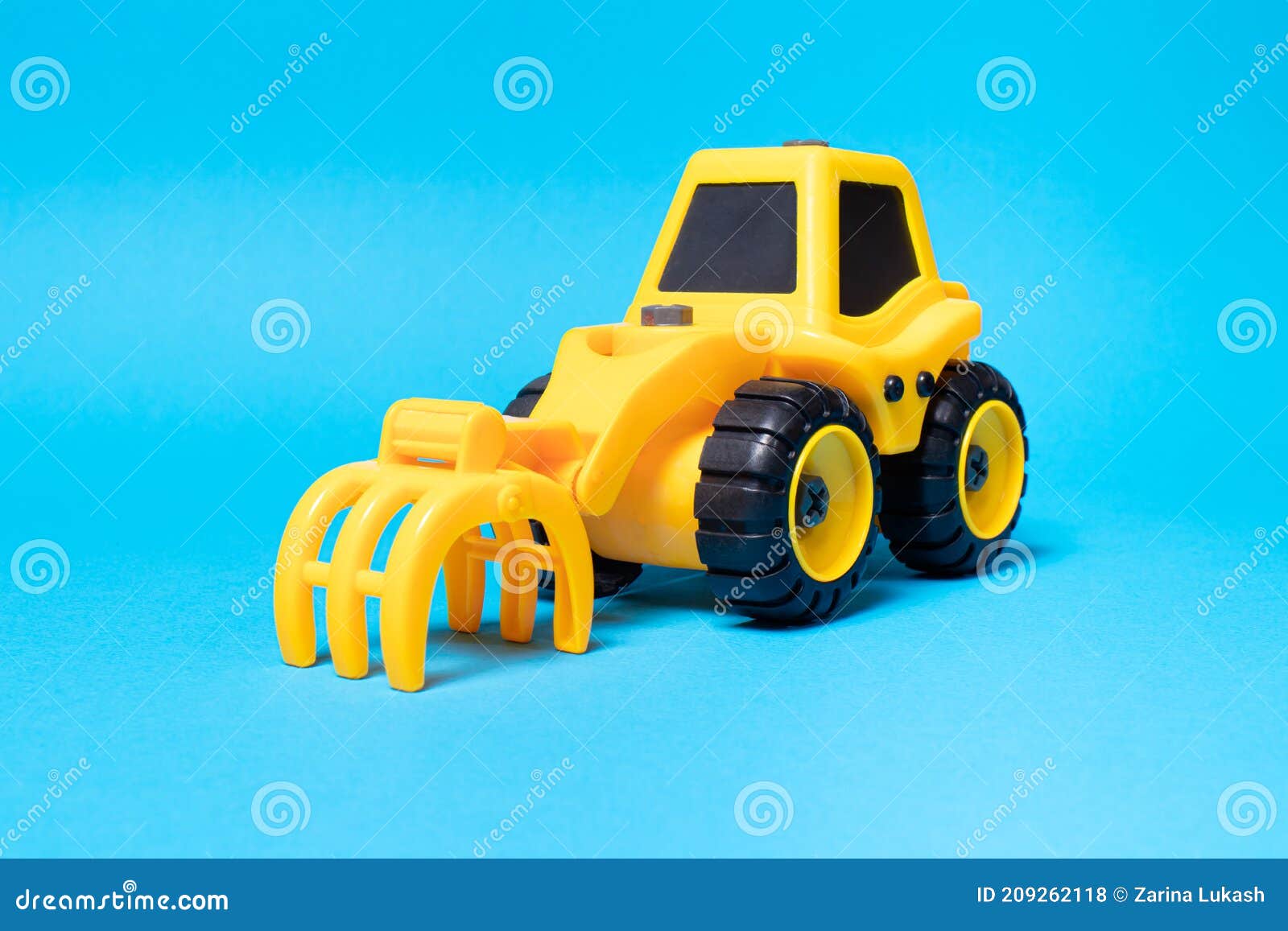 Yellow Toy Tractor with Rake Nozzle To Load the Forest on a Blue ...
