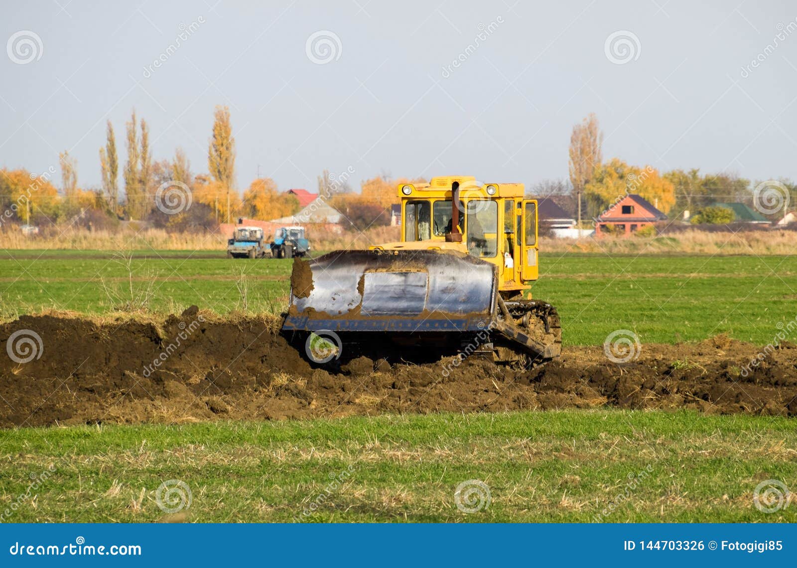 The Yellow Tractor with Attached Grederom Makes Ground Leveling Stock ...