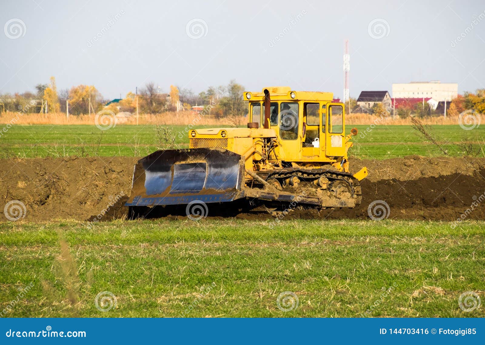 The Yellow Tractor with Attached Grederom Makes Ground Leveling Stock ...