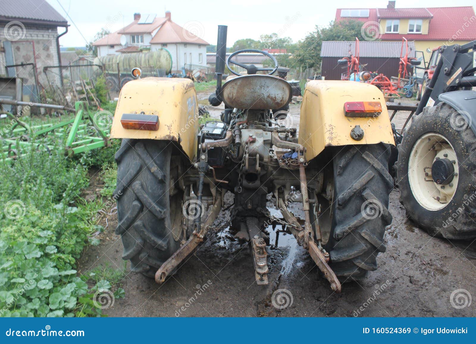 Yellow Tractor without a Cab in the Courtyard of a Dairy Farm. Stock ...