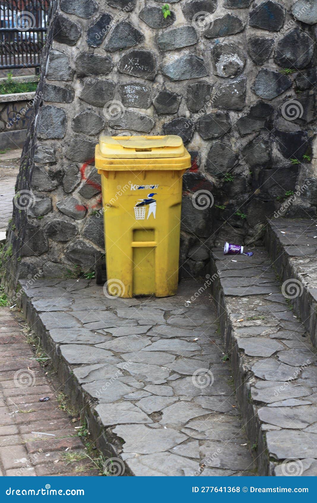 A Yellow Trash Can Standing on the Steps that Clearly Distracts the ...