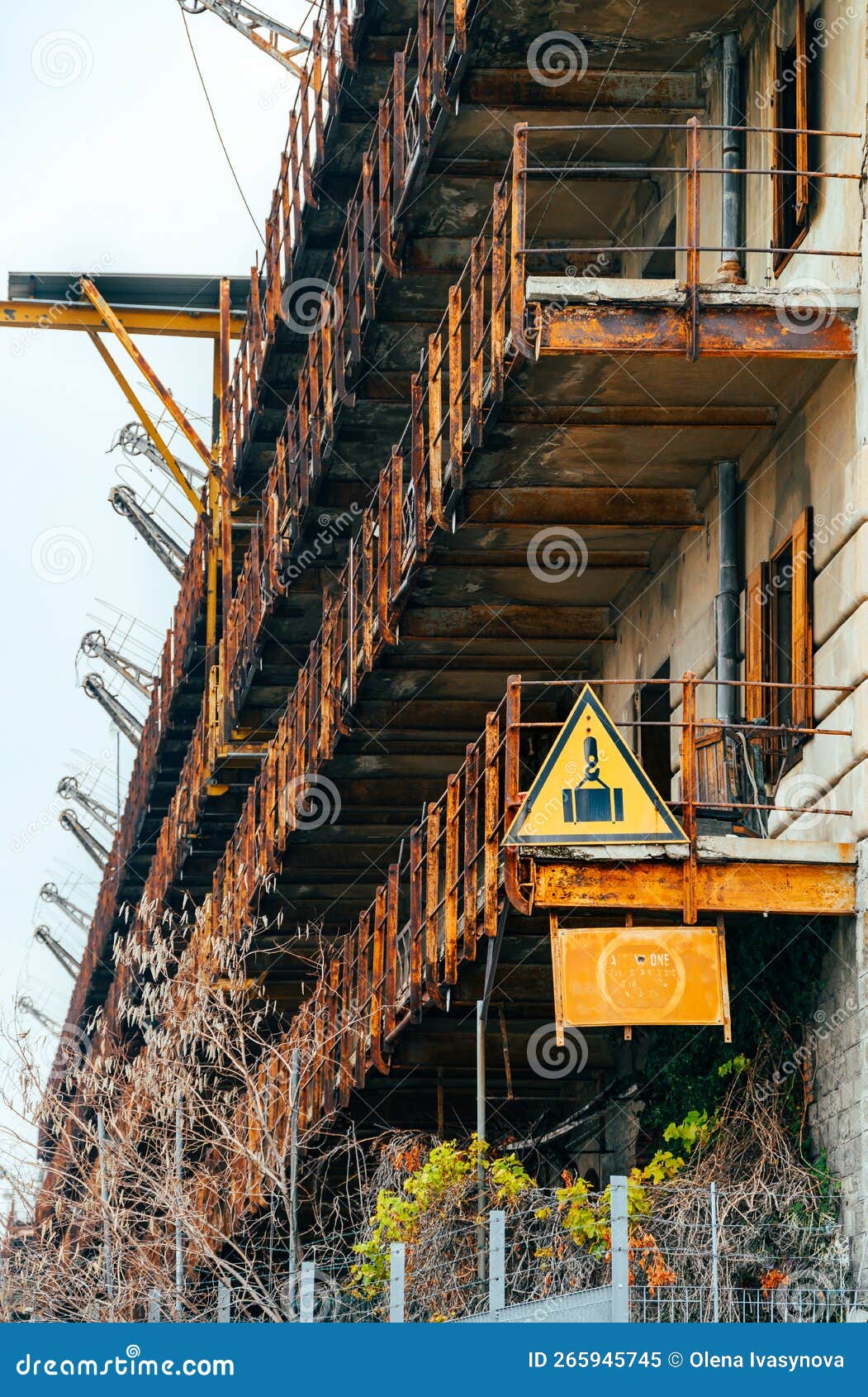 A Yellow Triangular Sign Hangs on the Dilapidated Rusty Balconies of an ...