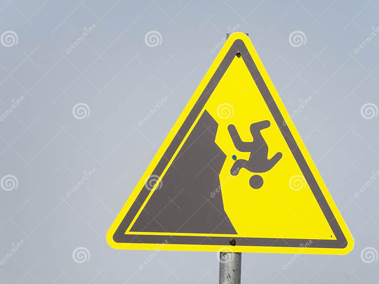Yellow Triangular Sign with a Man Falling from a Cliff on a Gray ...