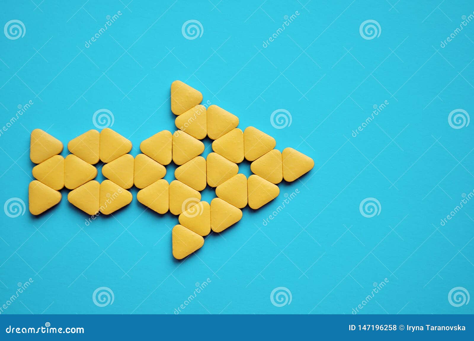 Yellow Triangular Unusual Pills Stacked in Form of Arrow To the Right ...
