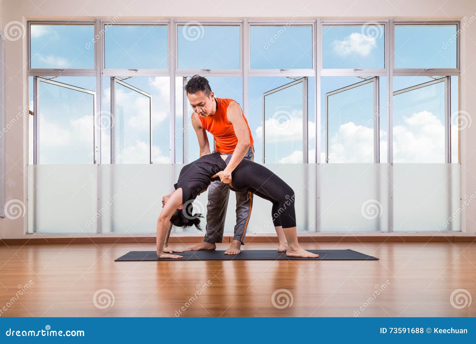 Yoga Instructor Assisting Student Perform Backbend or Chakrasana Pose ...