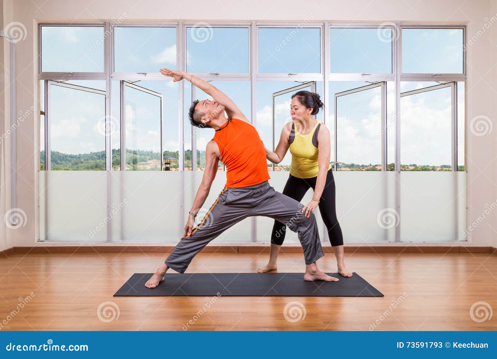 Yoga Instructor Guiding Student Perform Extended Side Angle Pose Stock ...