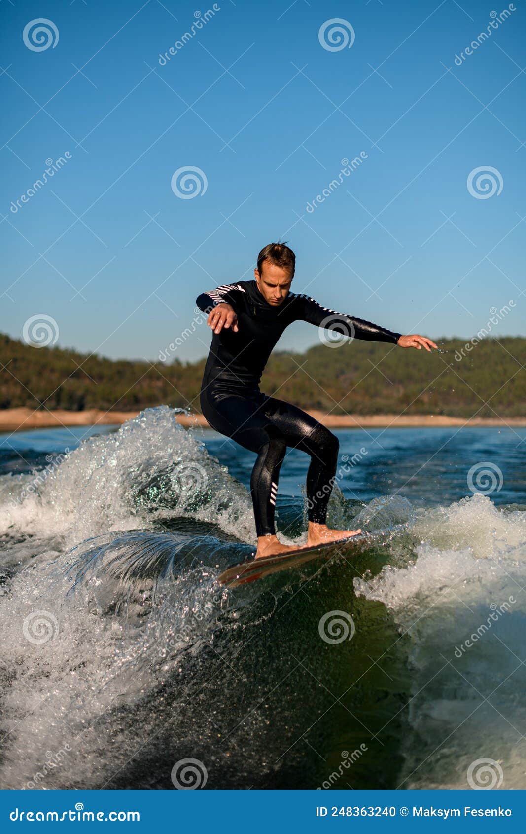 Young Active Man Energetically Balancing on a Wave on a Wakesurf Board ...