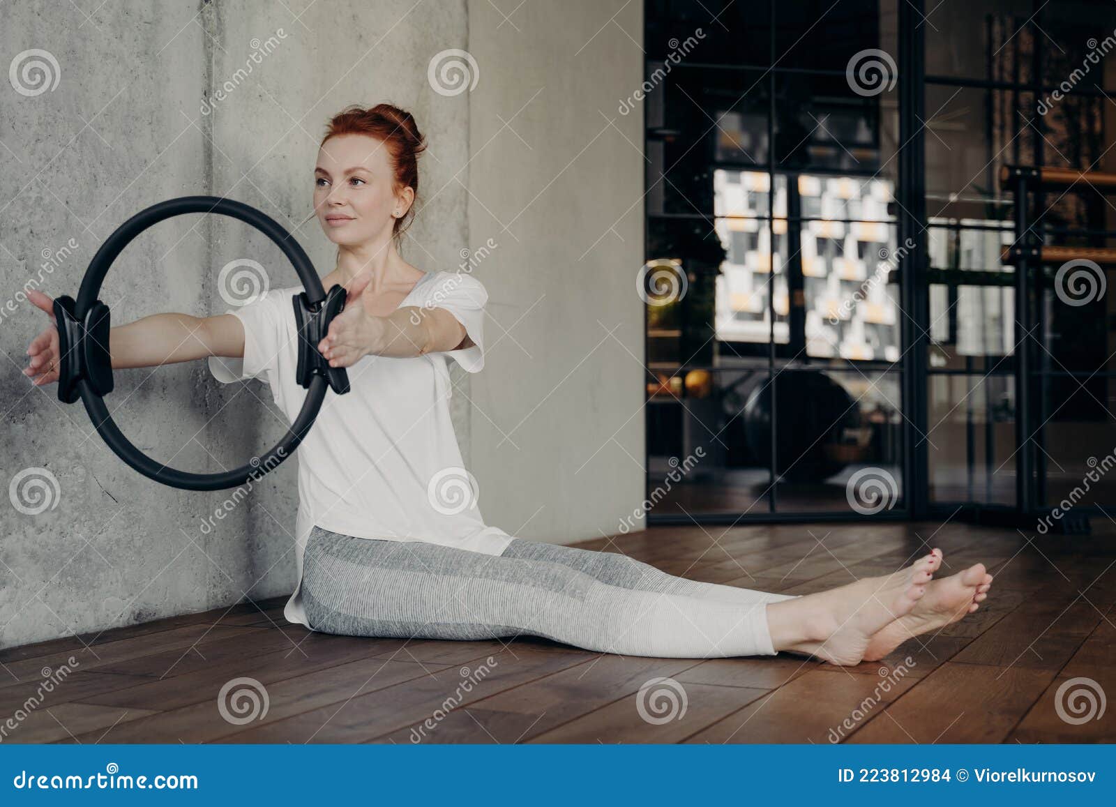 Young Focused Redhead Woman Doing Strength Exercises with Pilates Ring ...