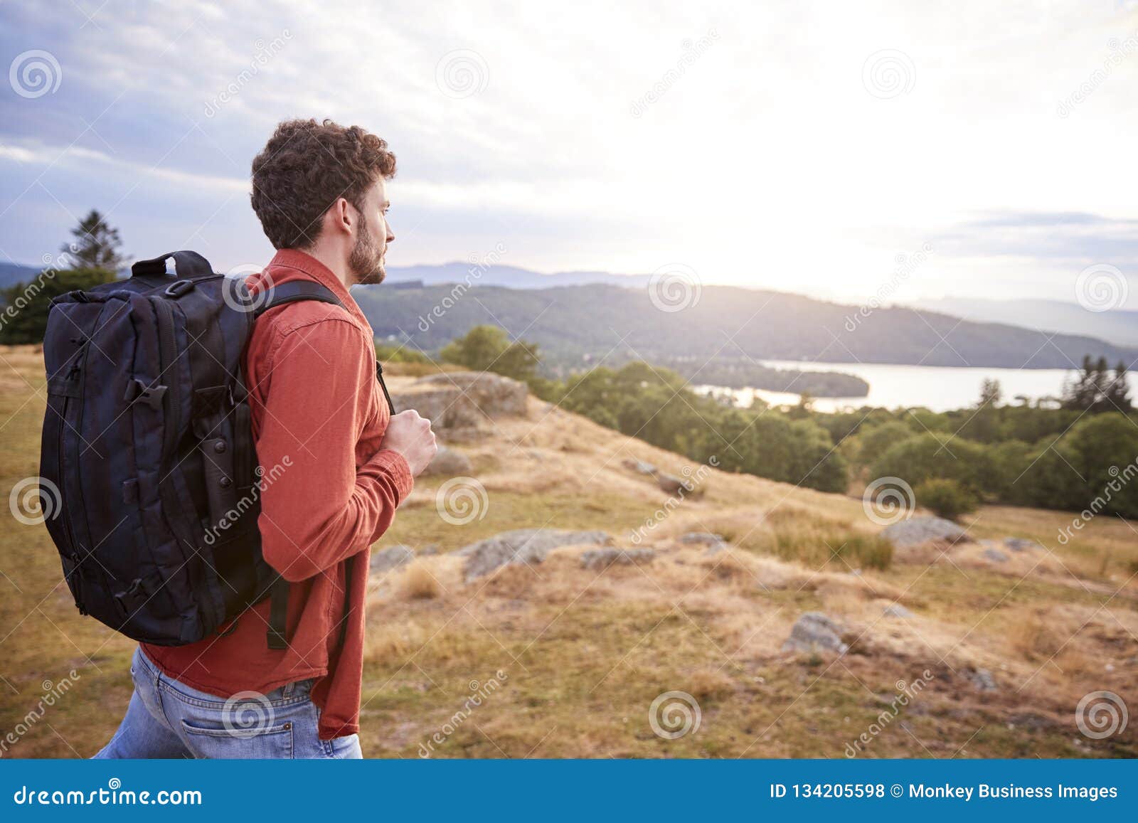 A Young Adult Caucasian Man Walking Alone on a Hill, Admiring the View ... A Young Adult Caucasian Man Walking Alone on a Hill, Admiring the View ...