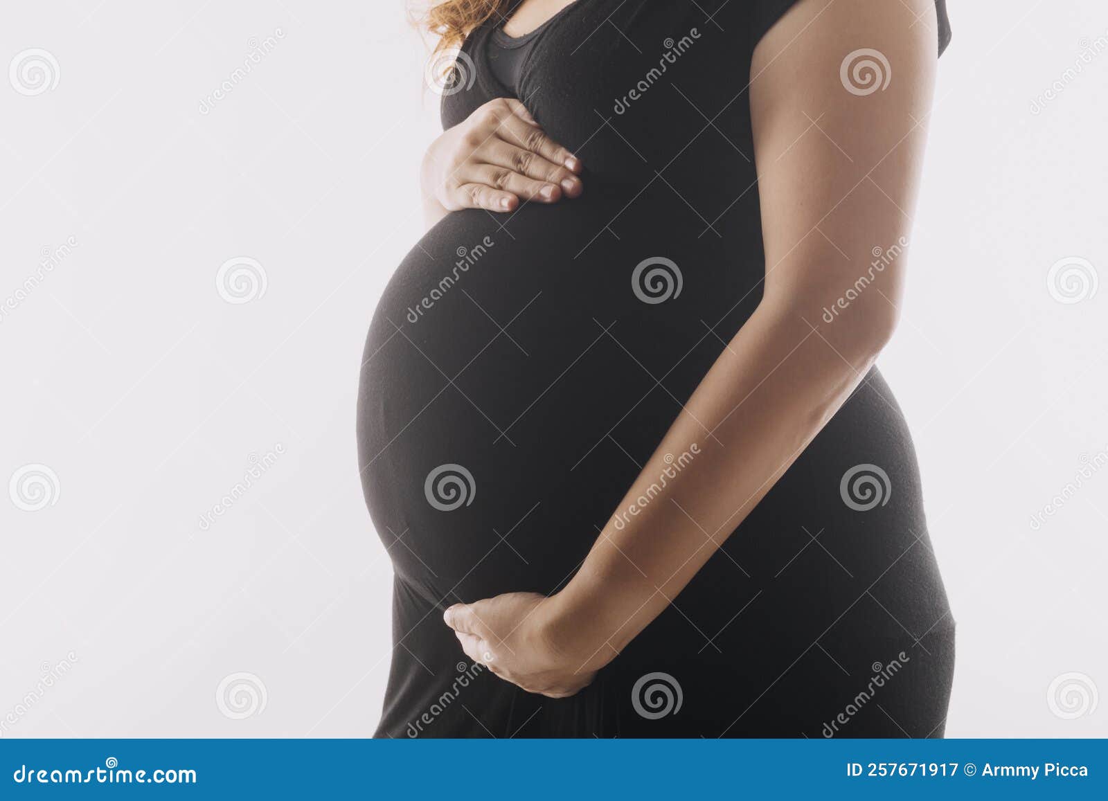 Young Adult Pregnant Woman In White Clothes Touching Big Naked Belly