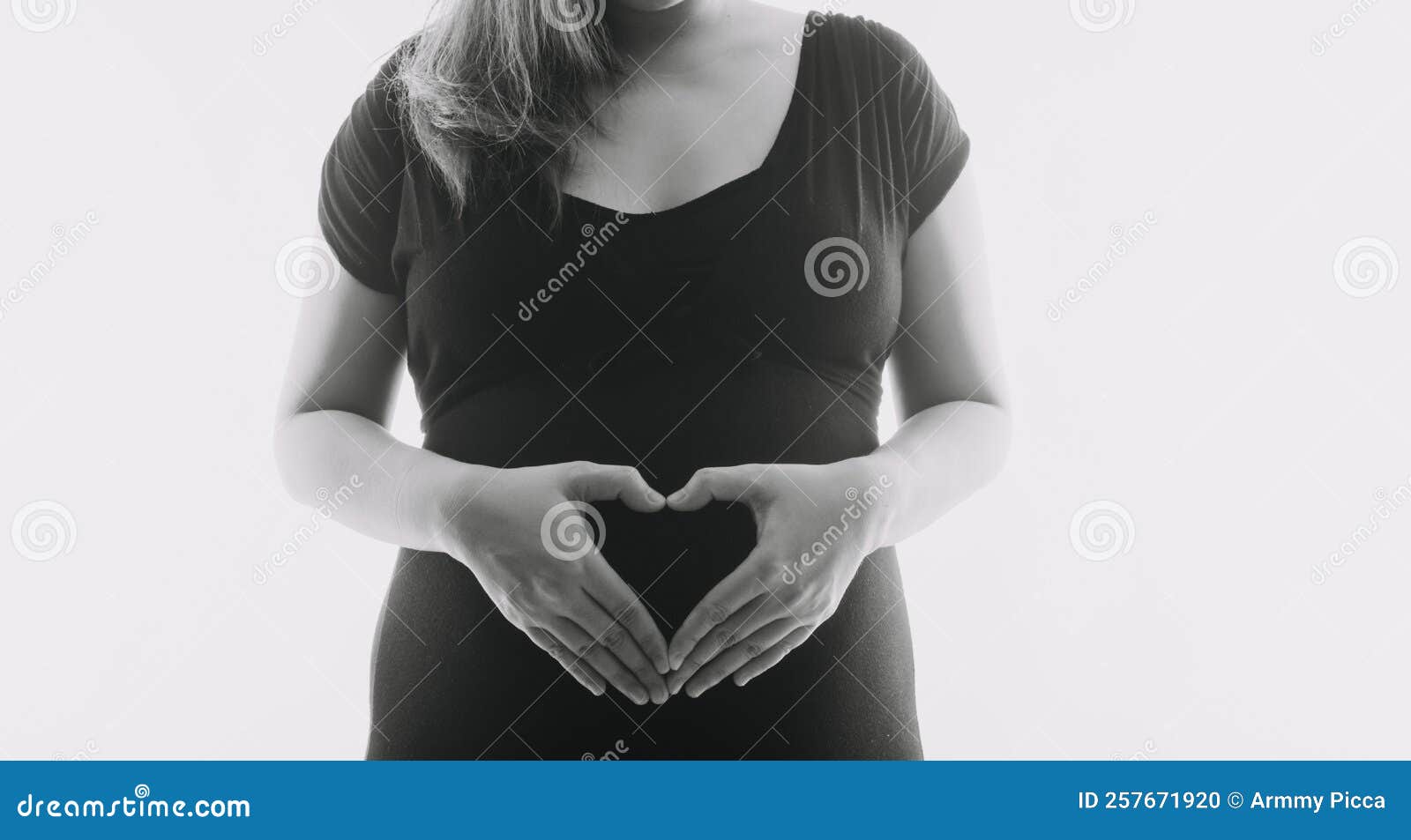 Young Adult Pregnant Woman In White Clothes Touching Big Naked Belly