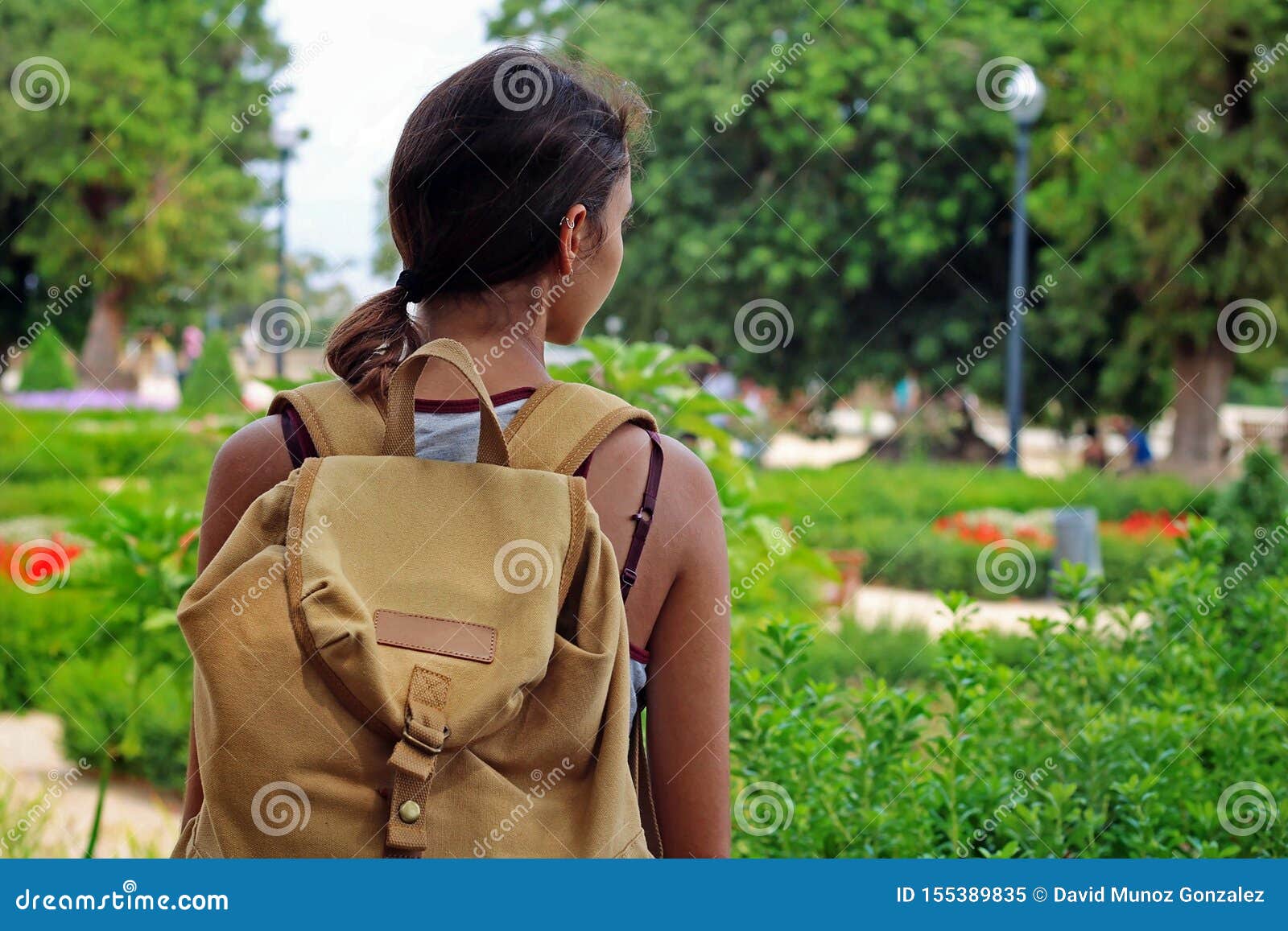 Adventurous Girl With A Yellow Hiking Backpack Looking At Nature Stock