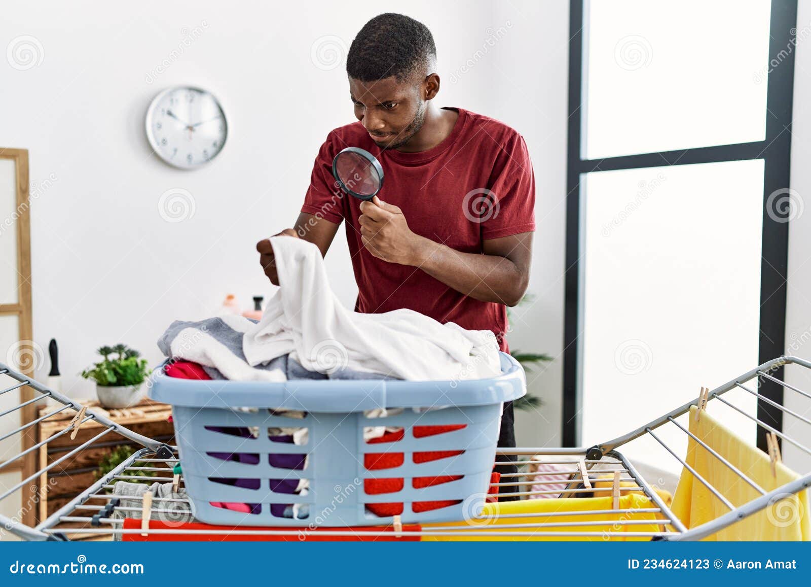 Young African American Man Looking Clothes Using Loupe at Laundry Room ...