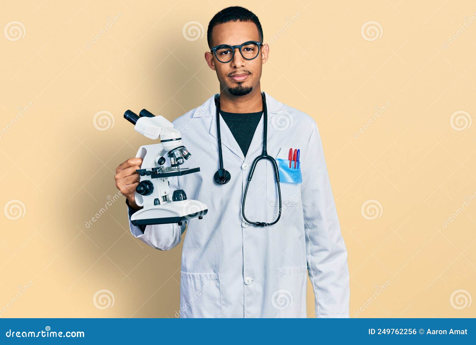 Young African American Man Wearing Scientist Uniform Holding Microscope ...