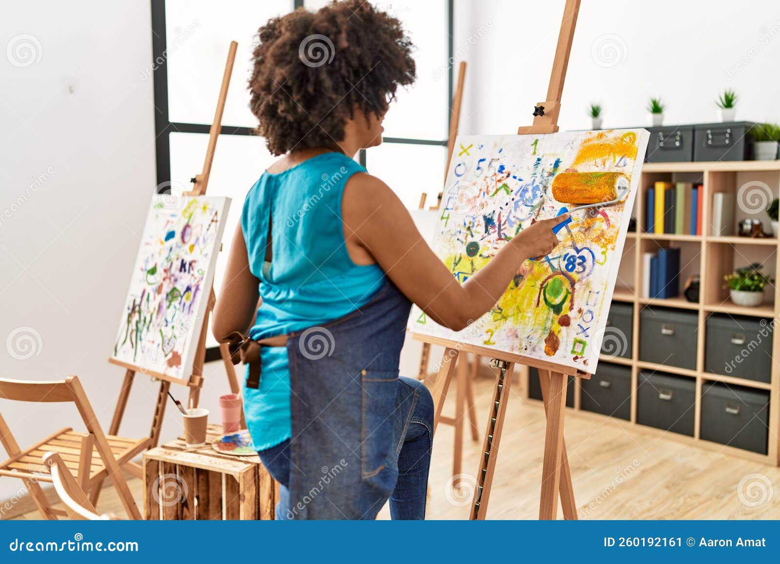 Young African American Woman on Back View Drawing Using Roller at Art ...