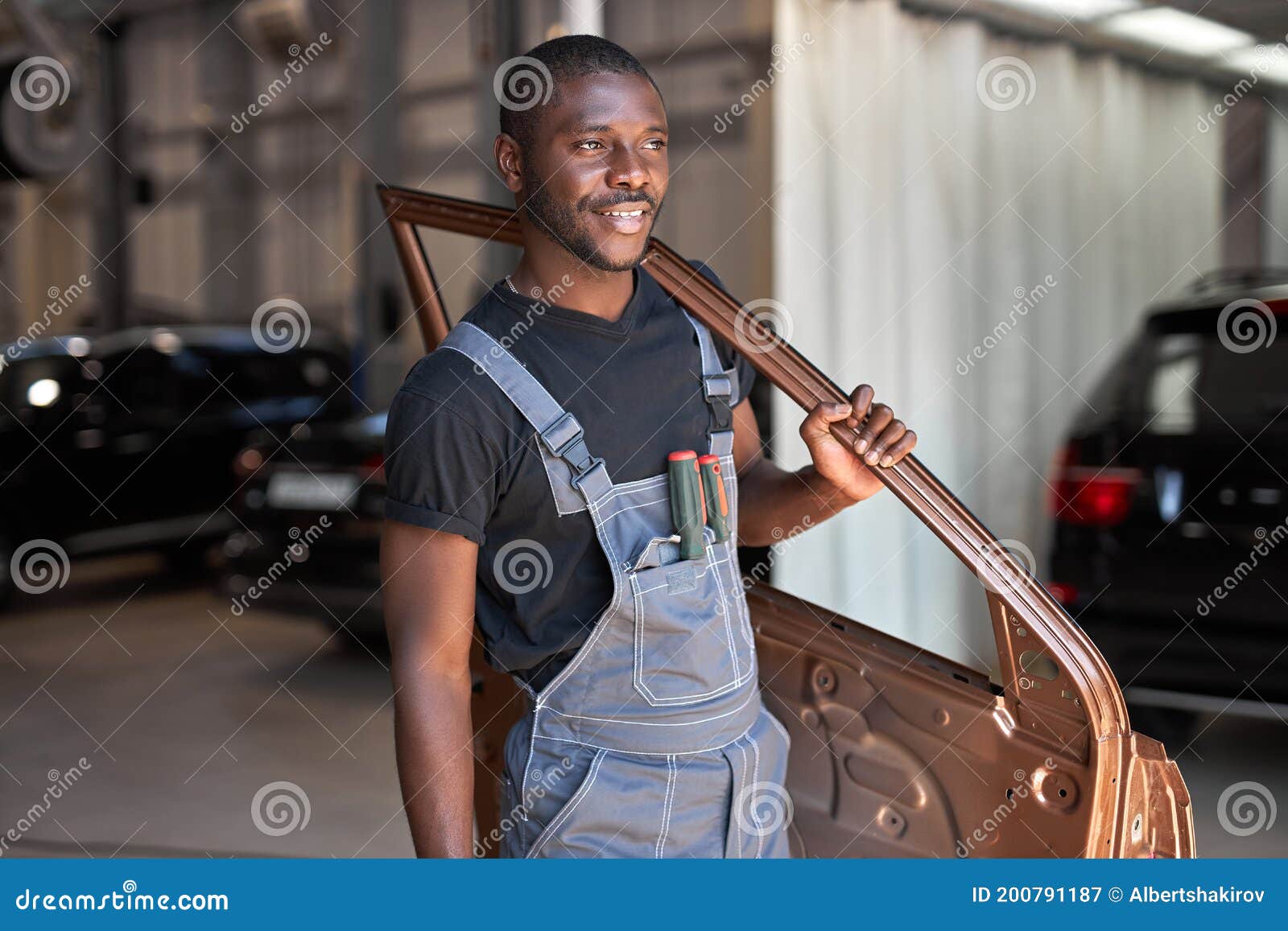 Young African Auto Mechanic at Work with Separate Part of the Machine ...