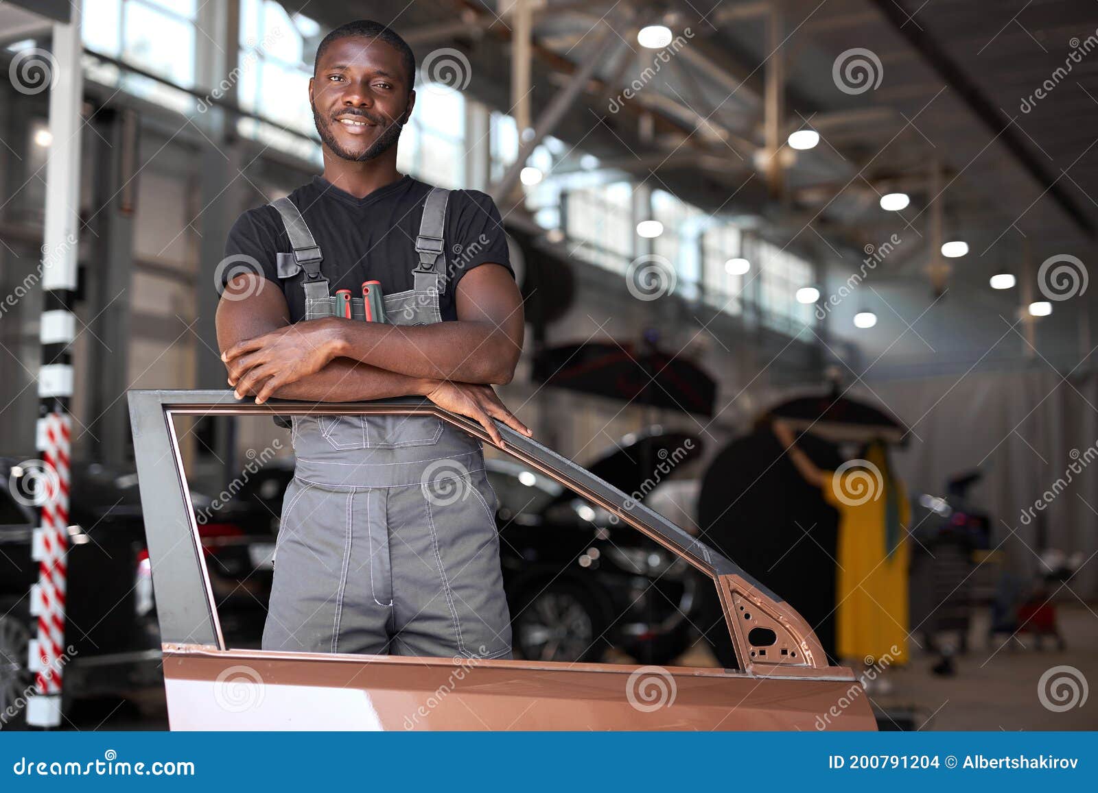 Young African Auto Mechanic at Work with Separate Part of the Machine ...