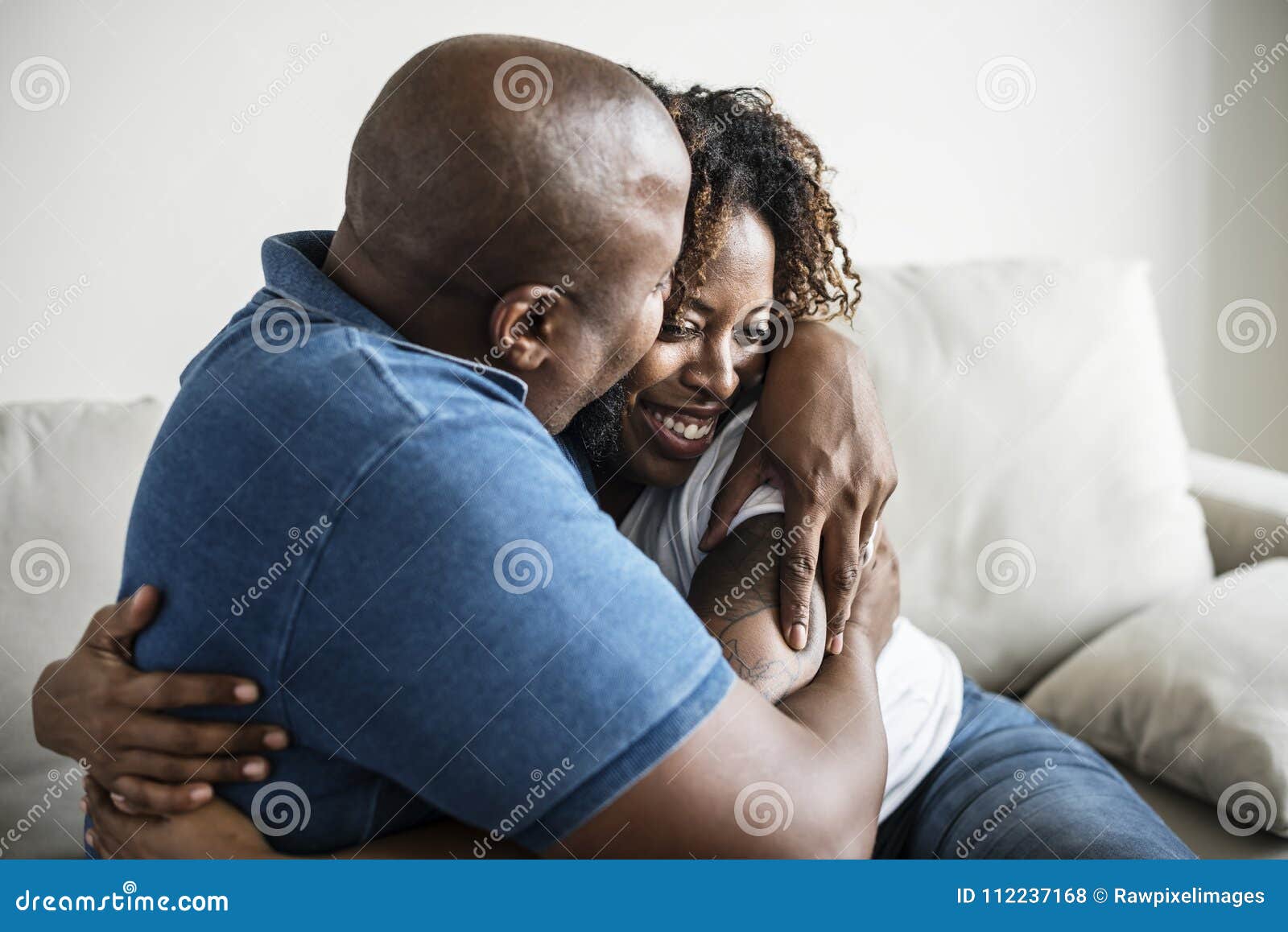 A Young African Cheerful Couple Hugging Stock Photo - Image of cuddling ...