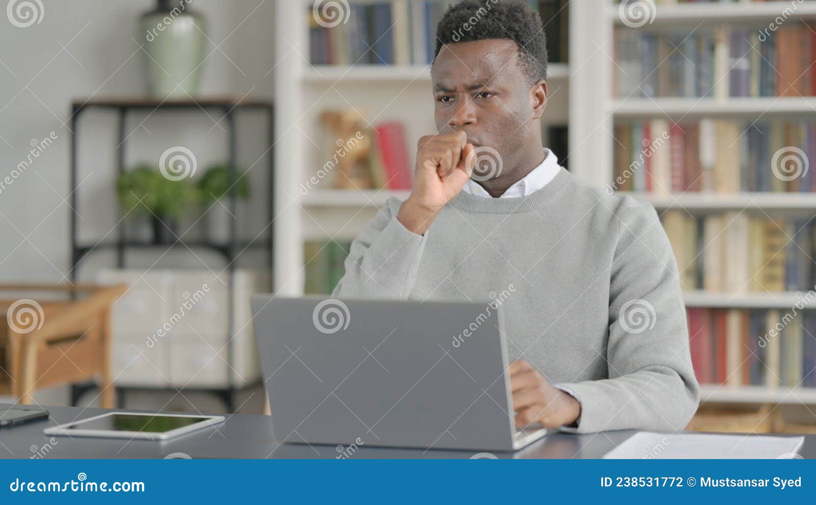 African Man Coughing while Using Laptop in Library Stock Photo - Image ...