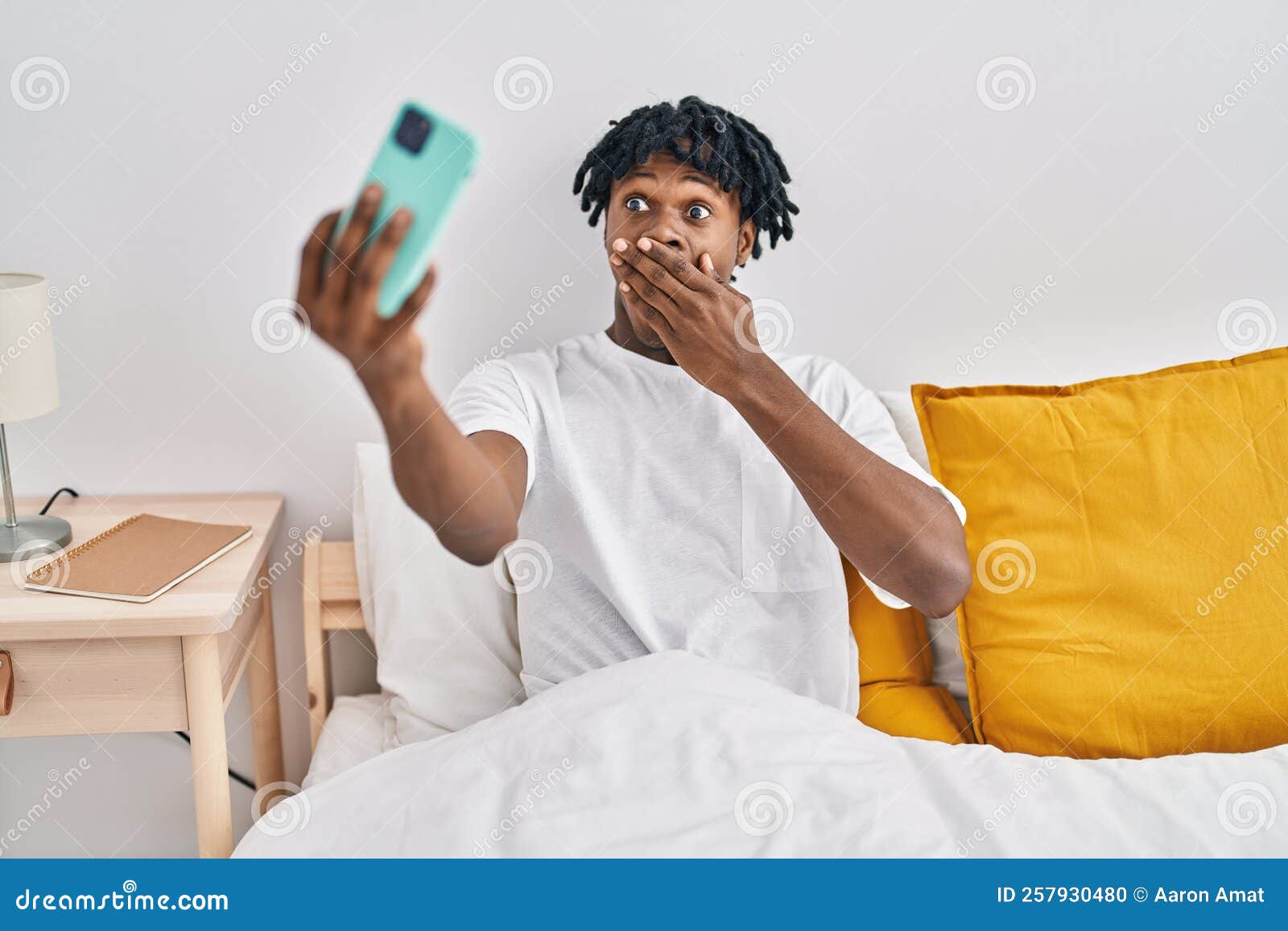 Young African Man With Dreadlocks Taking A Selfie On The Bed Covering