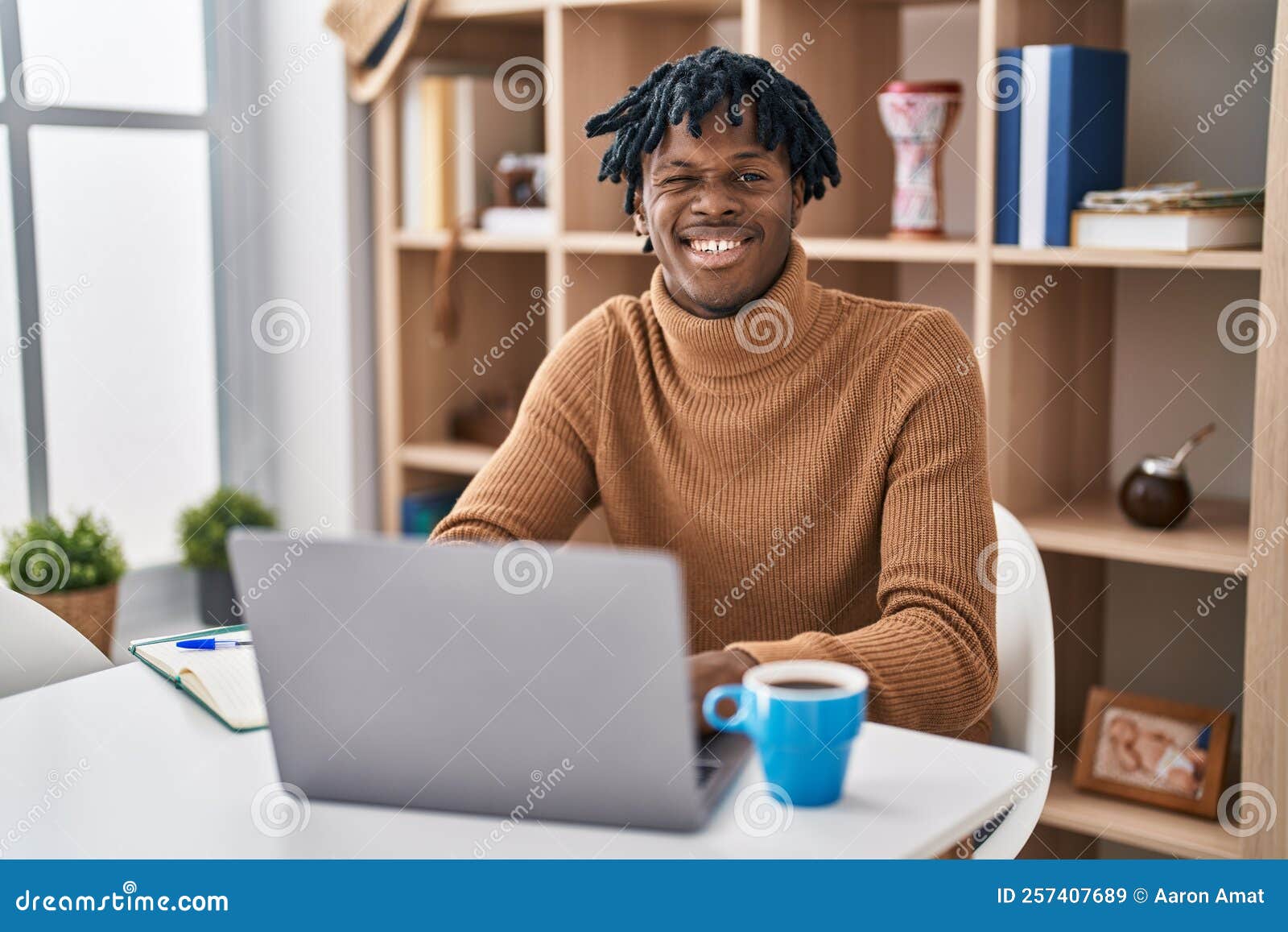 Young African Man with Dreadlocks Working Using Computer Laptop Winking ...