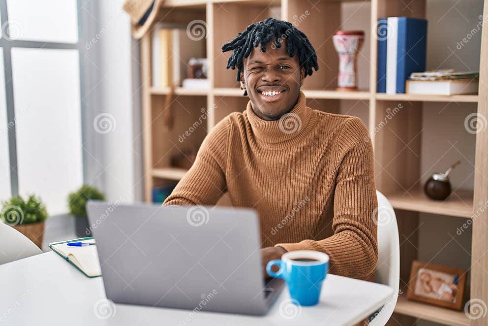 Young African Man with Dreadlocks Working Using Computer Laptop Winking ...