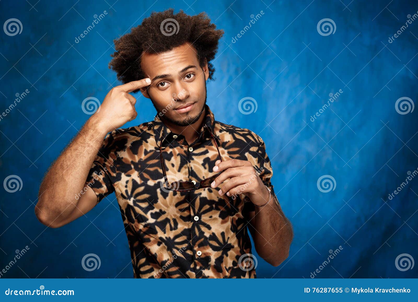 Young African Man Pointing Finger at Head Over Blue Backgrond. Stock ...
