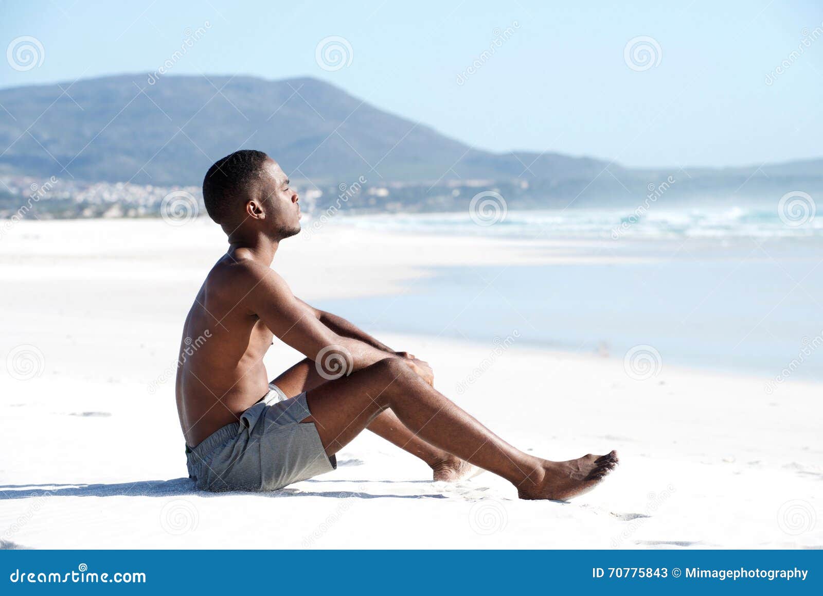 Young African Man Sitting Alone on the Beach Stock Image - Image of ...