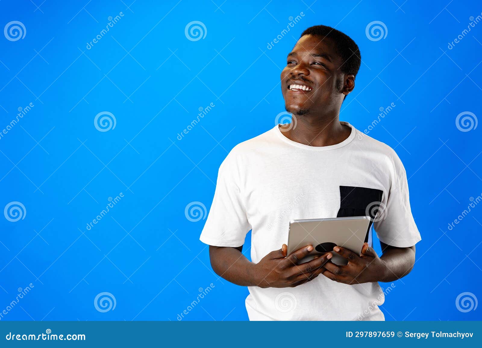 Young African Man Using Digital Tablet Against Blue Background Stock ...