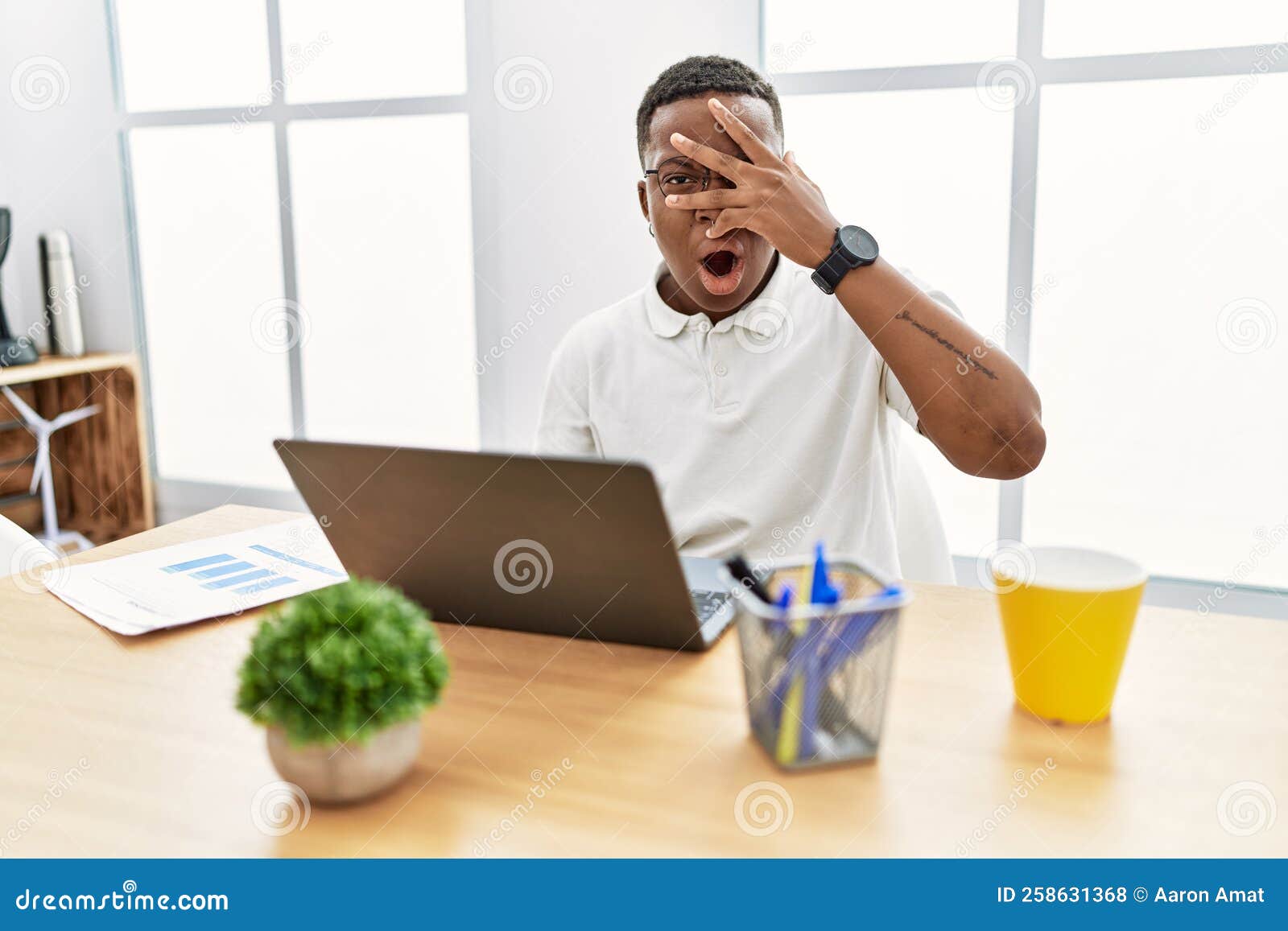 Young African Man Working at the Office Using Computer Laptop Peeking ...