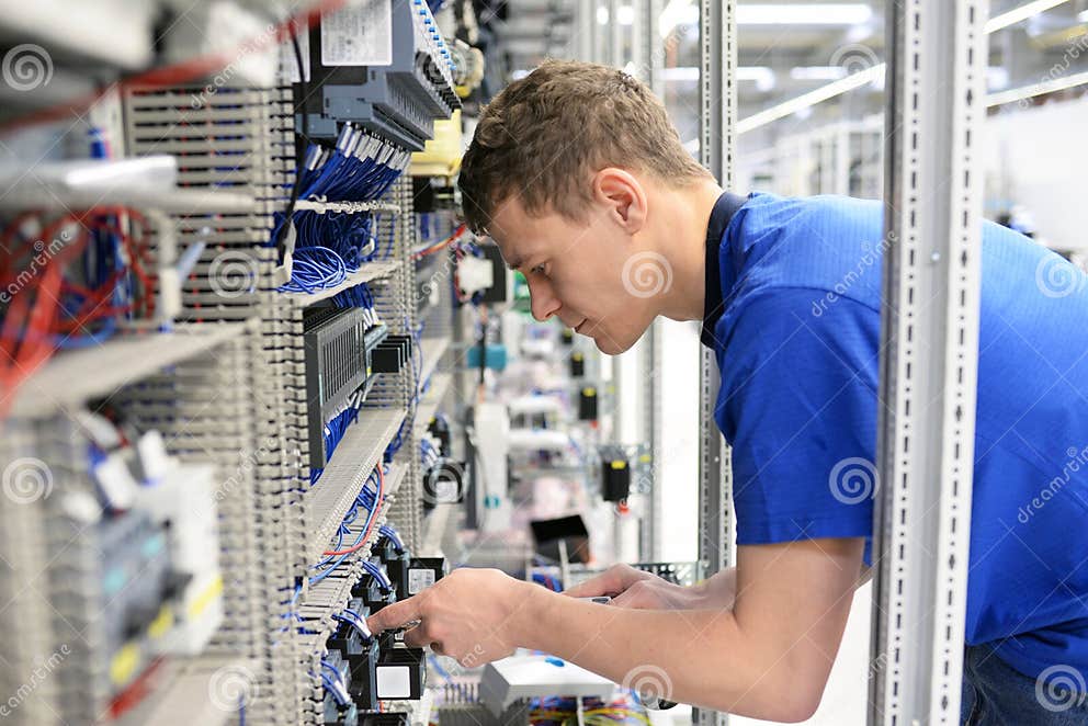 Young Apprentice Assembles Components and Cables in a Factory in a ...