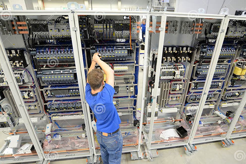 Young Apprentice Assembles Components and Cables in a Factory in a ...