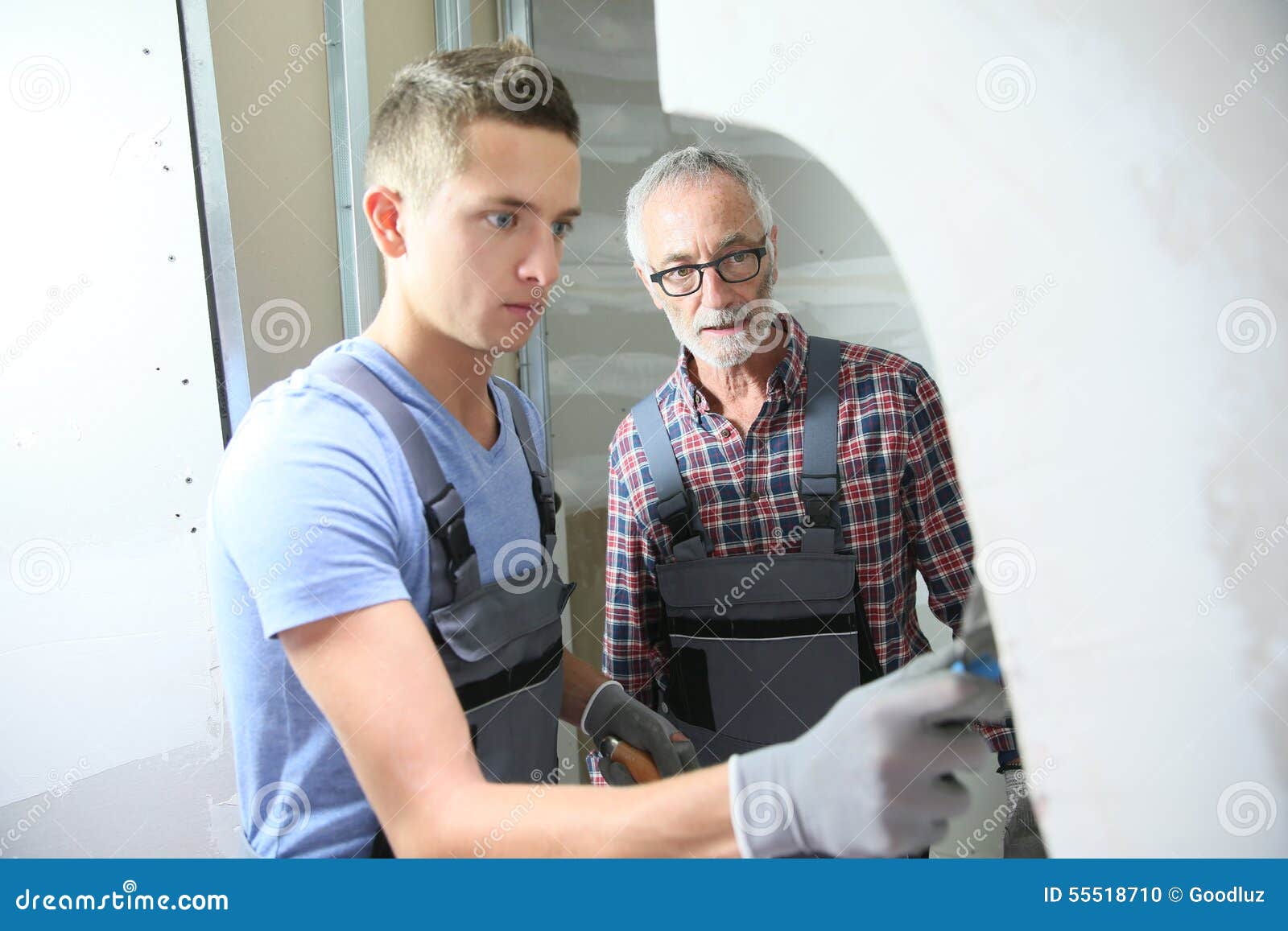 Young Apprentice with Plastery Instructor Working the Wall Stock Photo ...