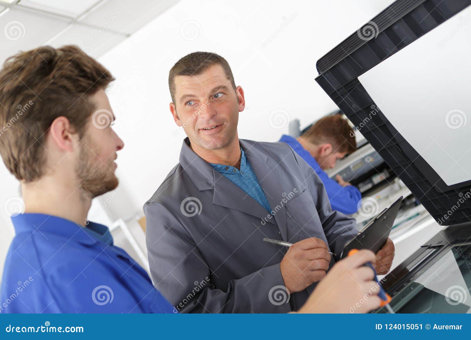 Young Apprentice Repairing Photocopier with Instructor Stock Image ...