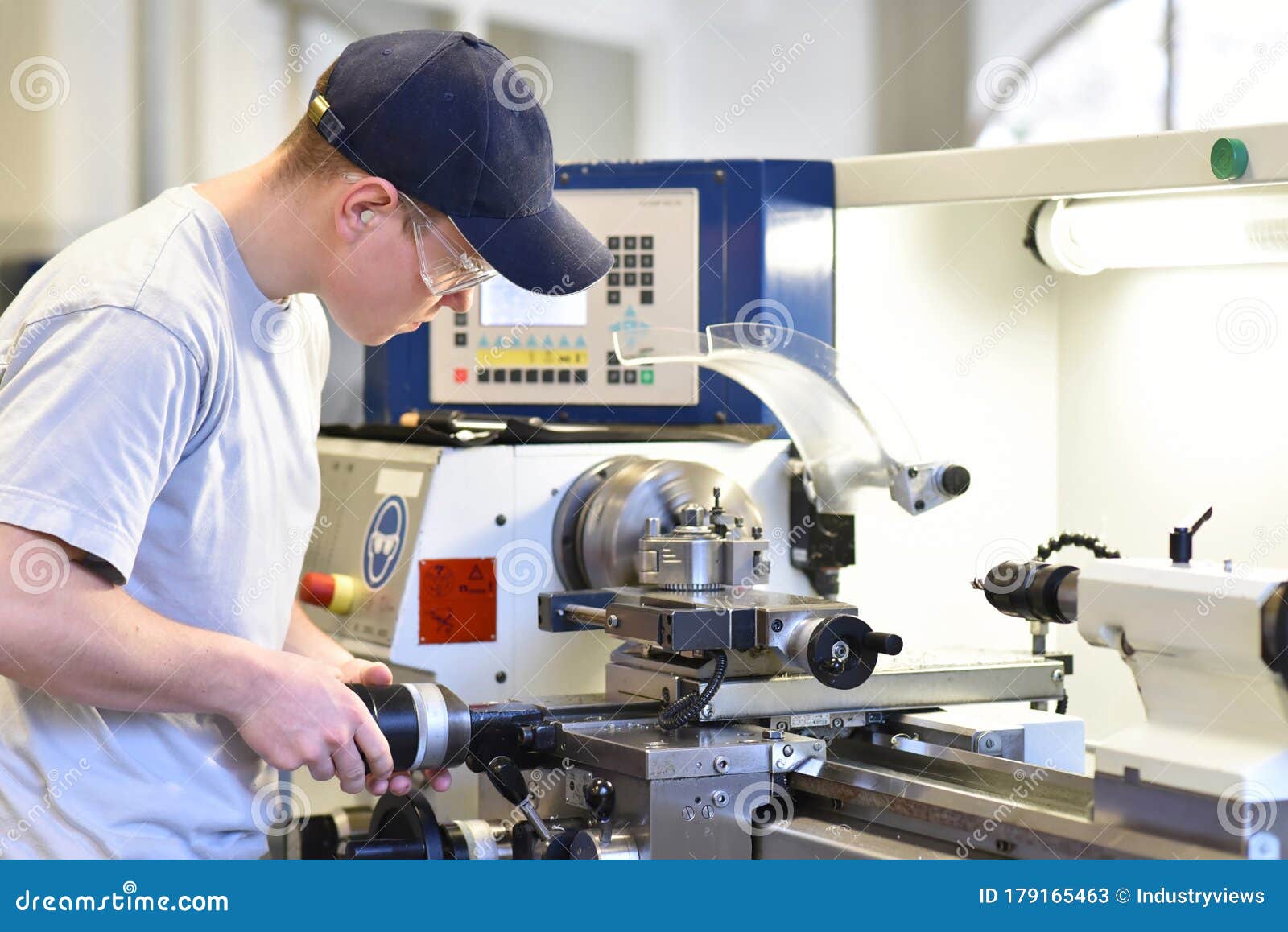 Young Apprentice in Vocational Training Working on a Turning Machine in ...