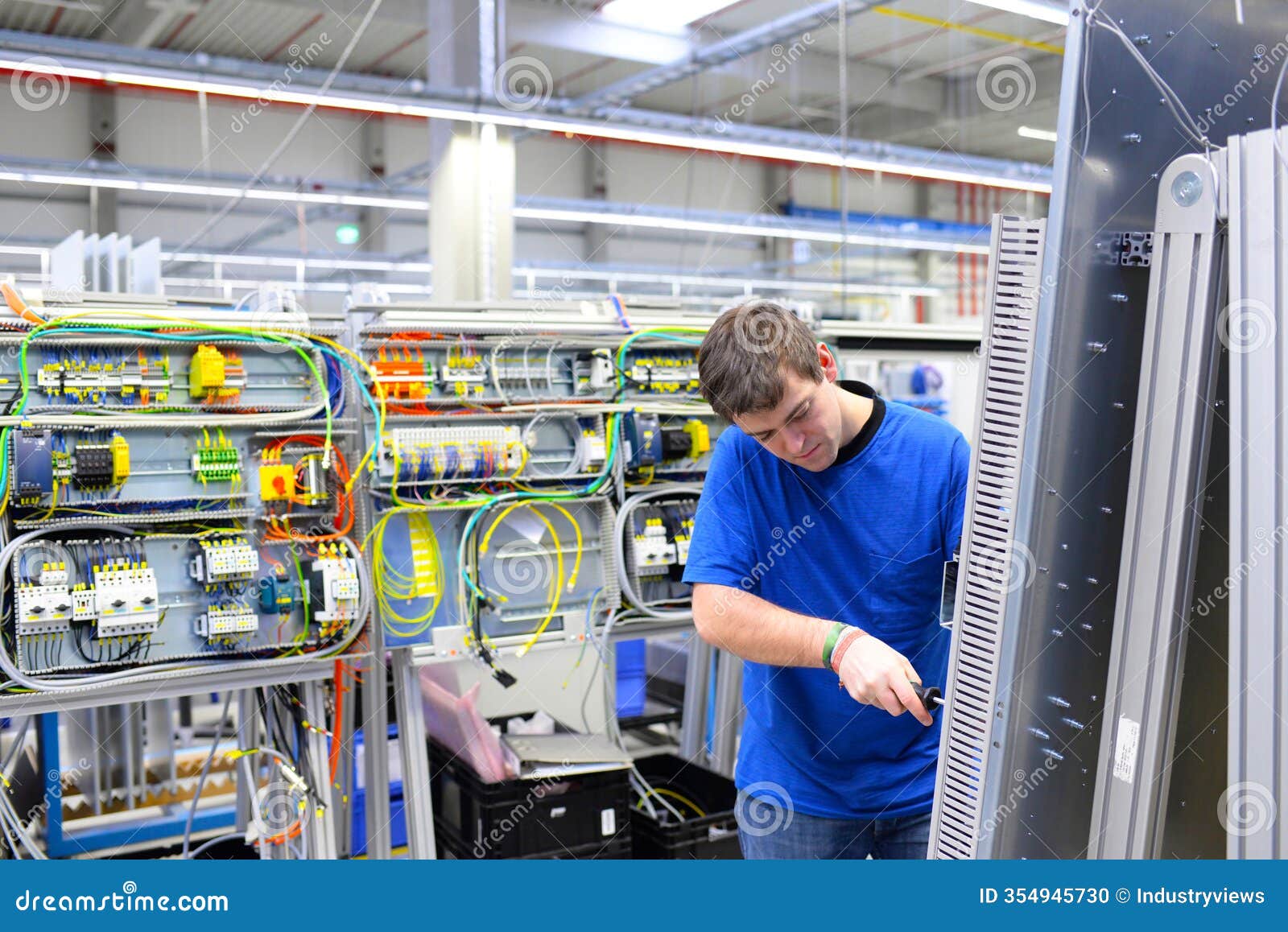 Young Apprentice Worker in an Industrial Company Assembling Electronic ...