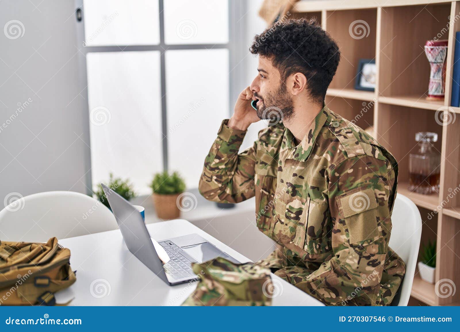 Young Arab Man Army Soldier Using Laptop Talking on the Smartphone at ...