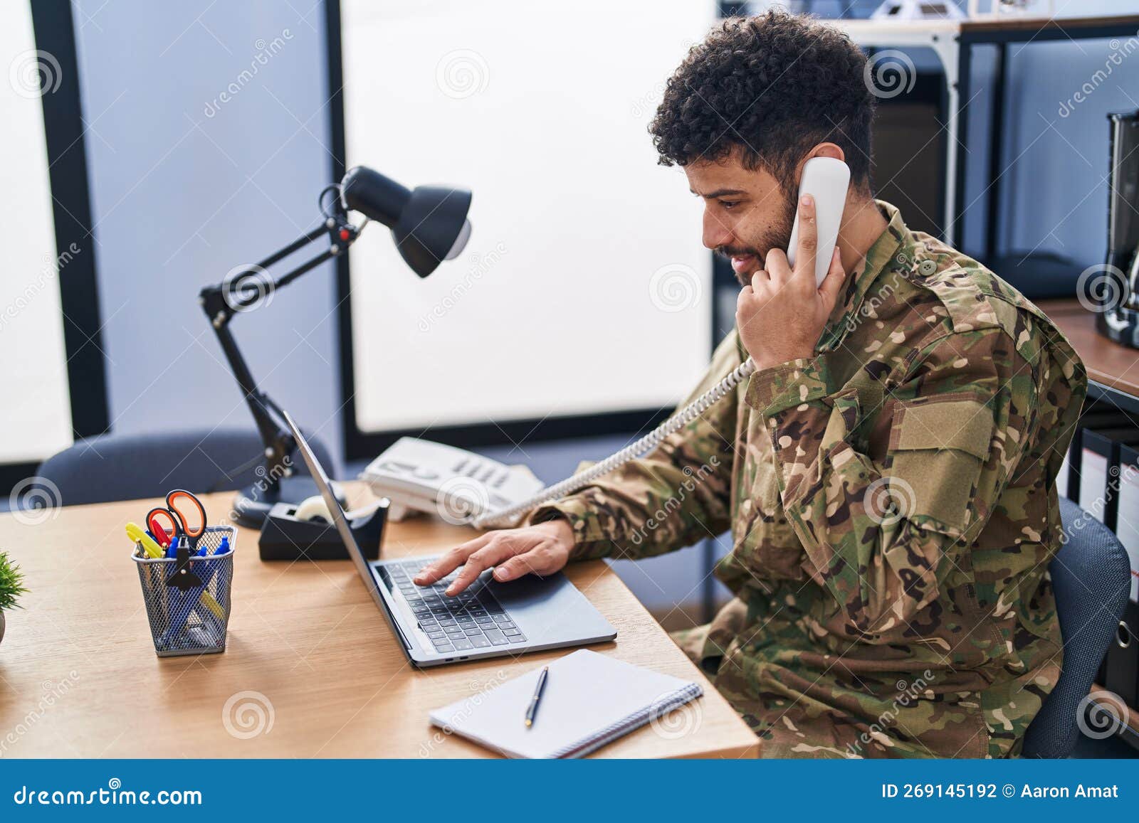 Young Arab Man Army Soldier Using Laptop Talking on the Telephone at ...