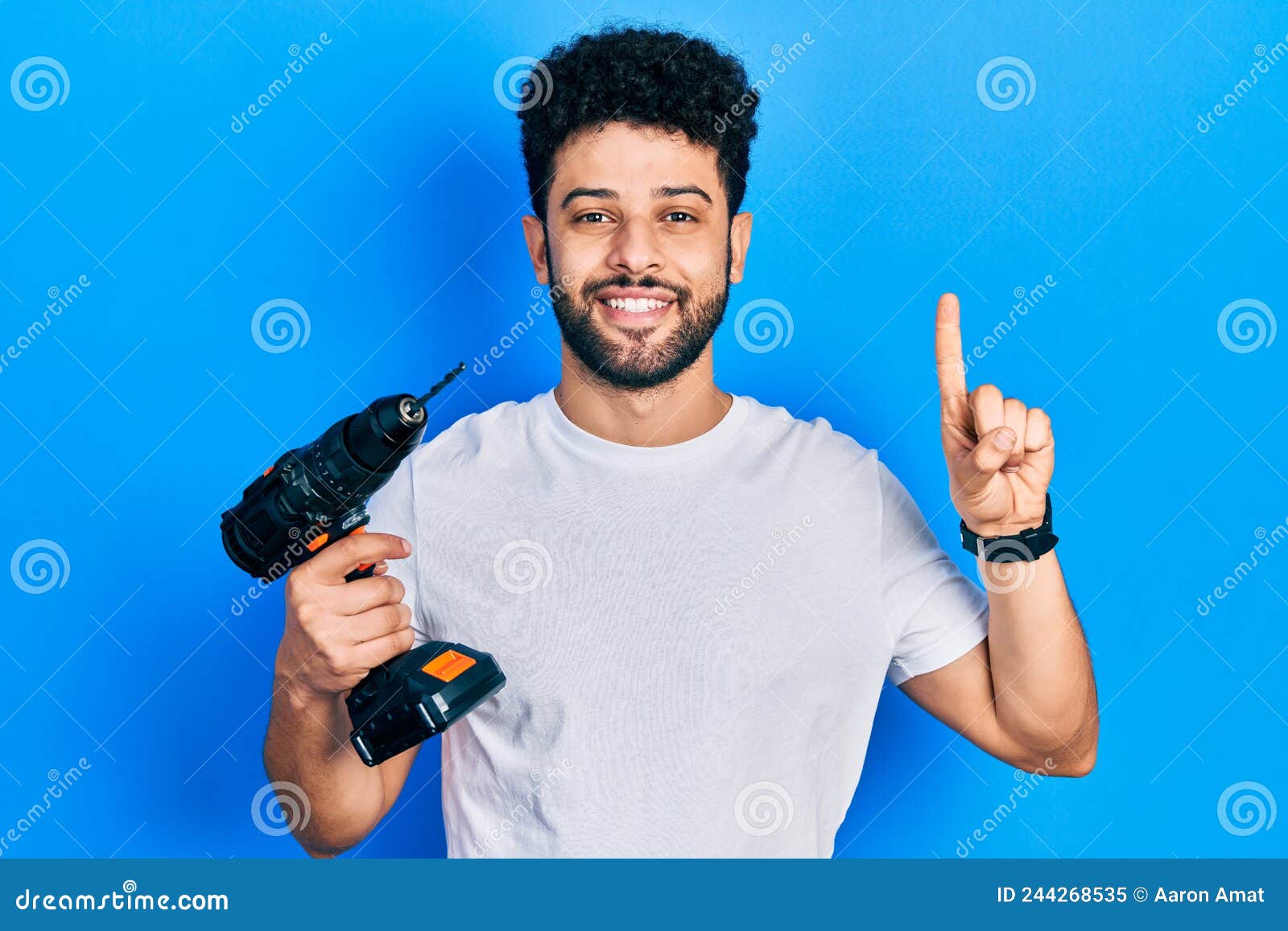 Young Arab Man with Beard Using Drill Smiling with an Idea or Question ...