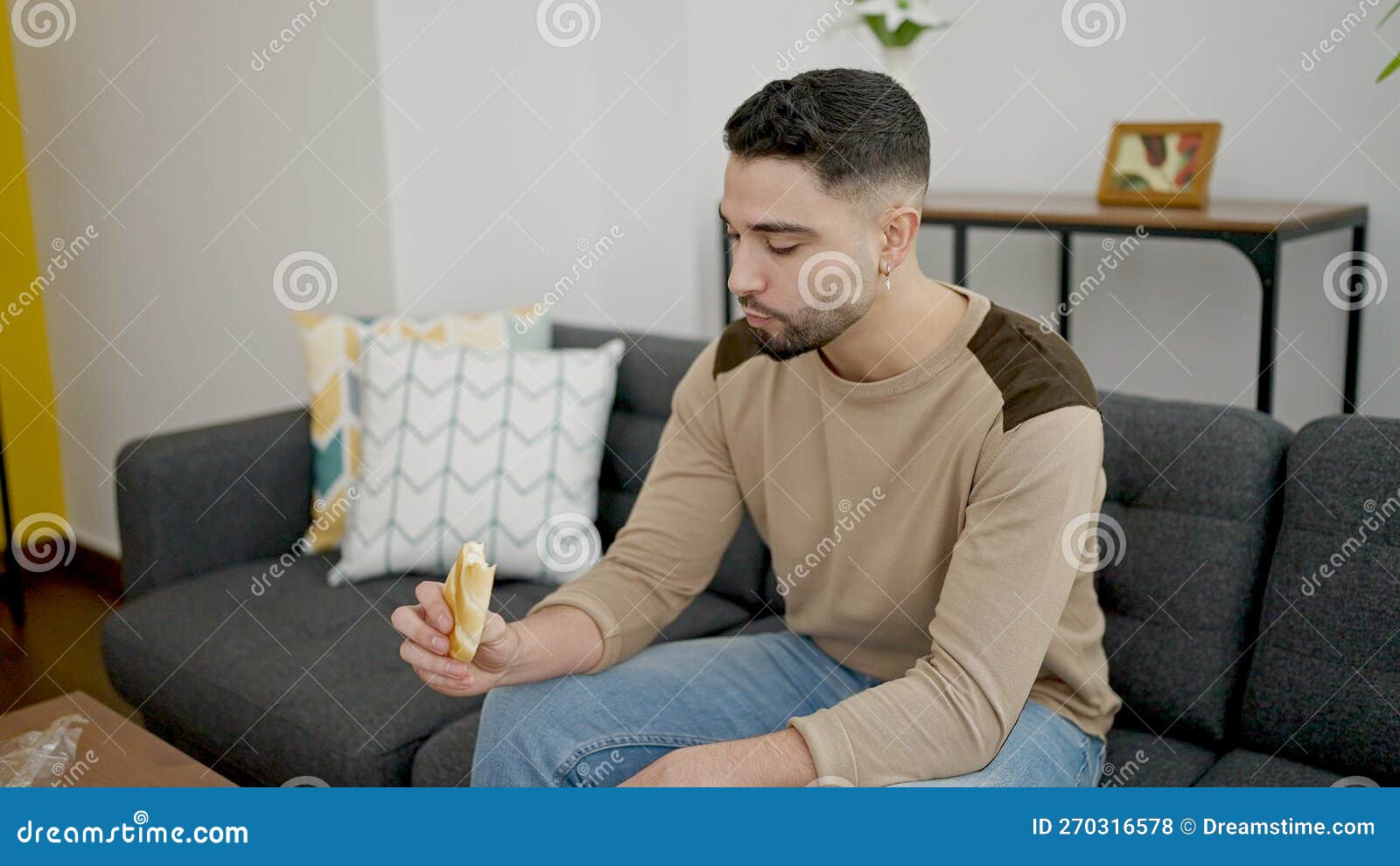 Young Arab Man Eating Cake Sitting on Sofa at Home Stock Photo - Image ...
